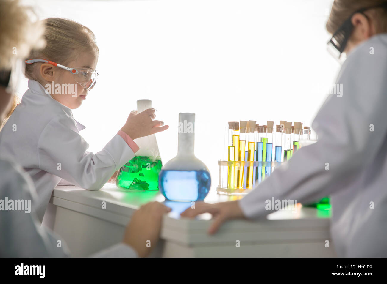 Schoolchildren making experiment with test tubes and flasks in chemical ...