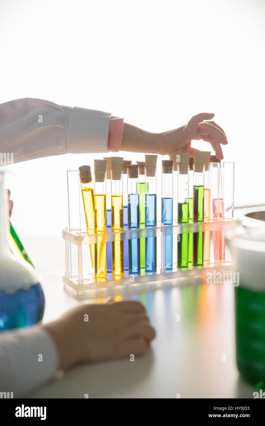 Schoolchild making experiment with test tubes in chemical laboratory ...