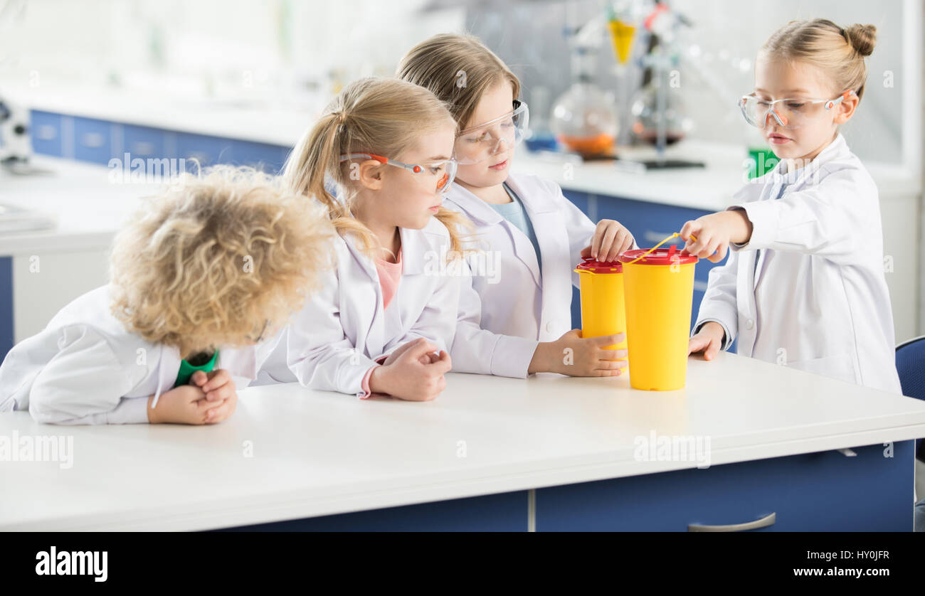 Four kids in science laboratory making experiment Stock Photo - Alamy