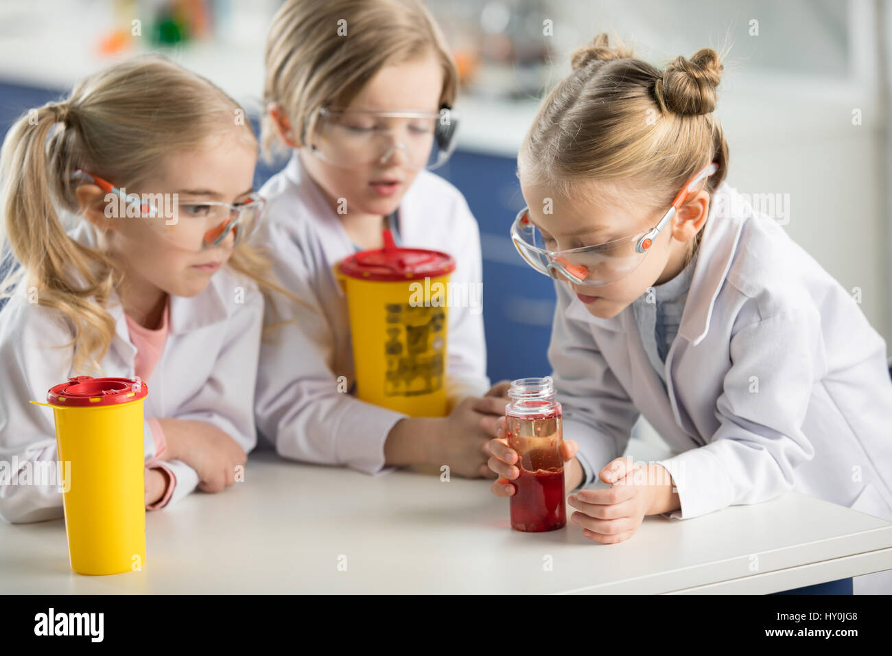 Kids in protective glasses making experiment in laboratory Stock Photo ...