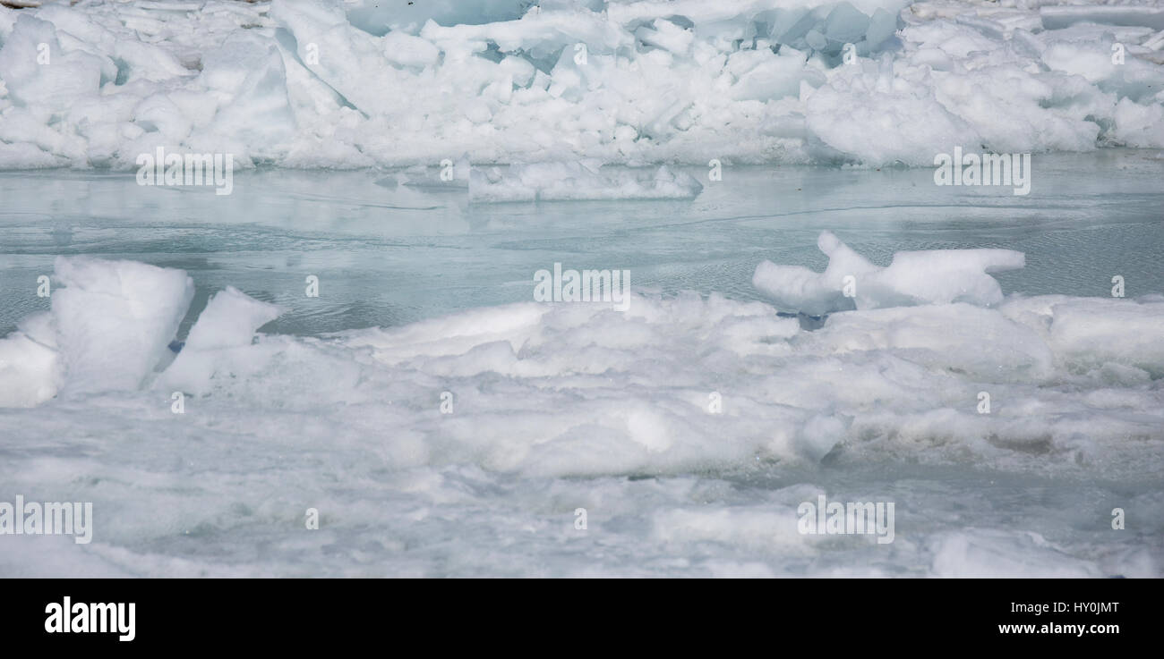 Transparent blue ice hummocks on lake Baikal shore. Siberia winter landscape view. Snow-covered ...