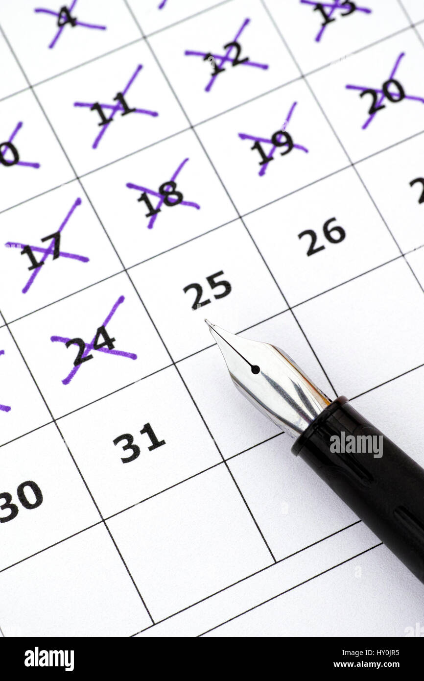 Fountain pen marking days on calendar. Close-up Stock Photo - Alamy