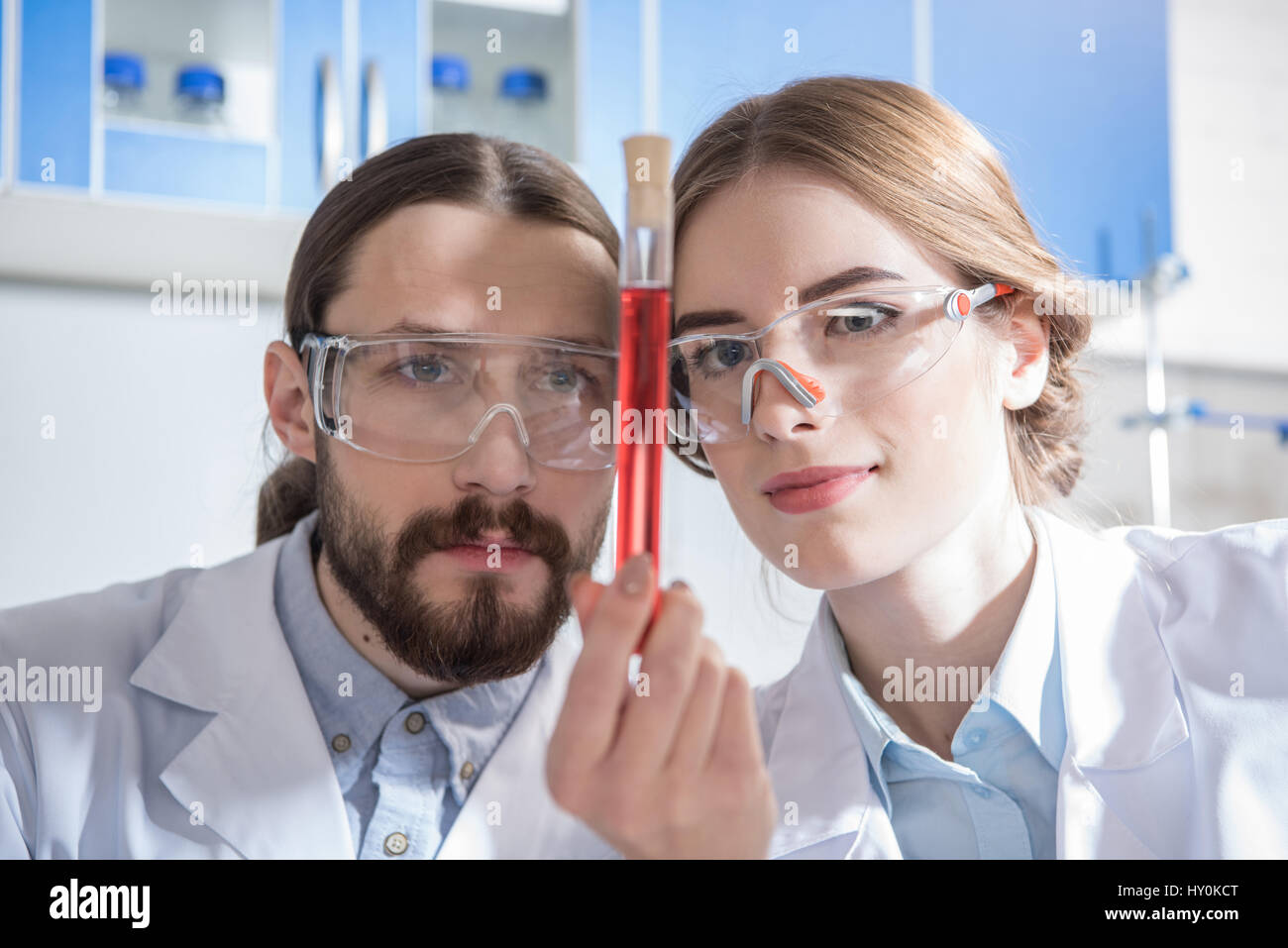 Two young scientists holding chemical sample in test tube Stock Photo ...