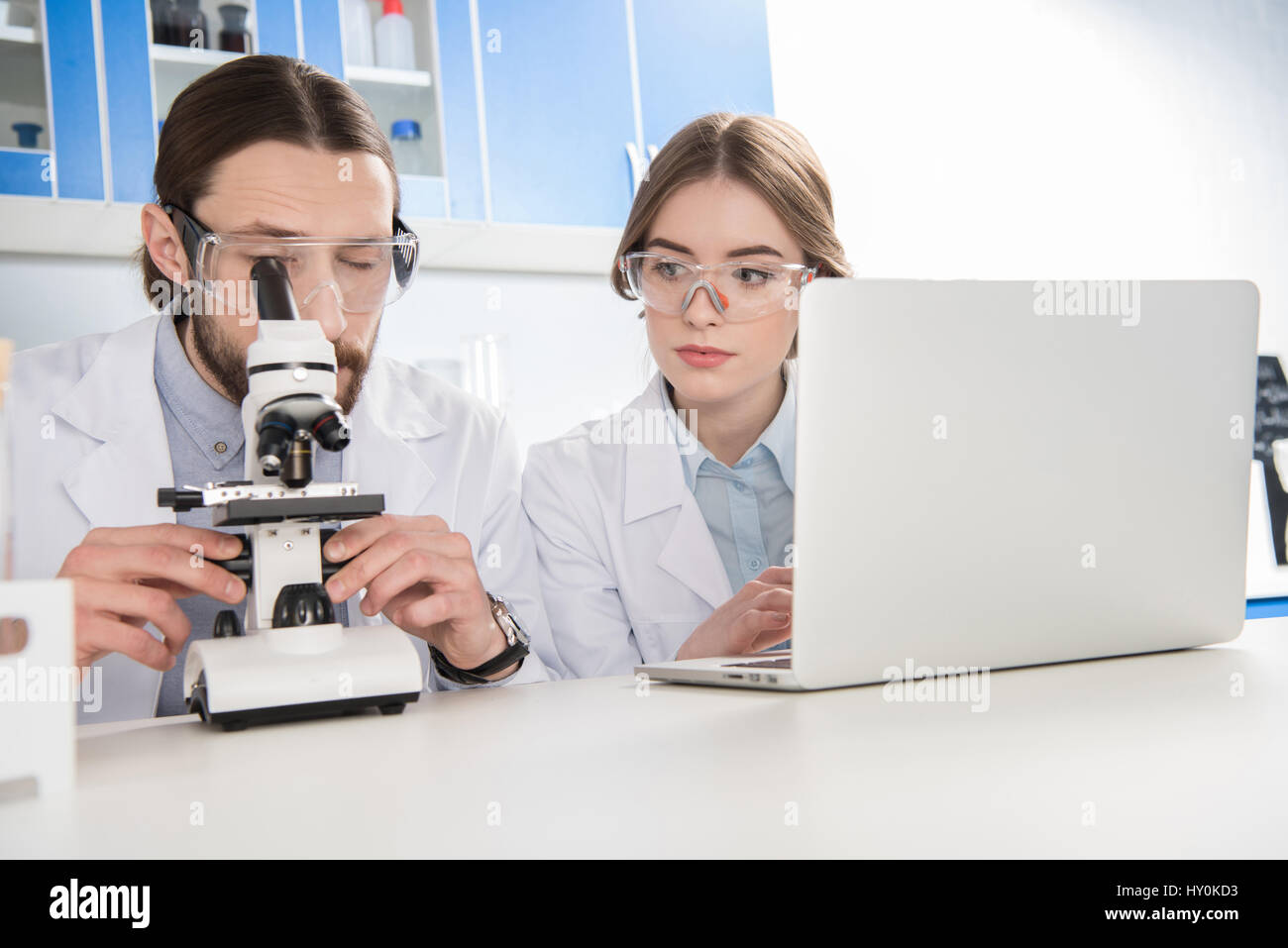 Scientists using microscope in laboratory hi-res stock photography and ...