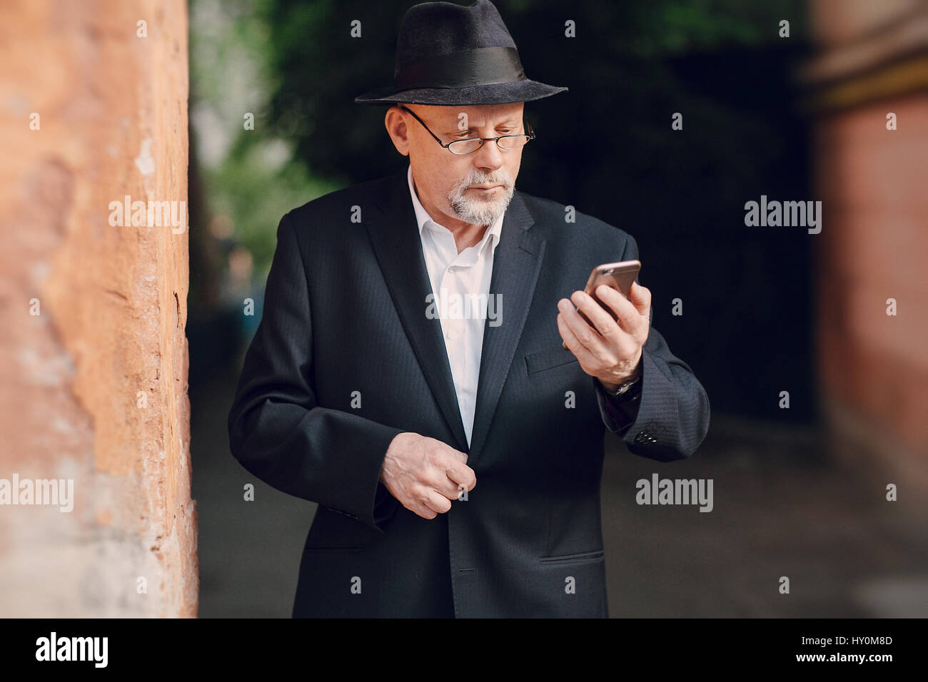 the old man uses the phone in the street Stock Photo - Alamy