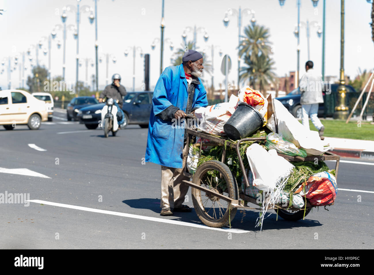 Homeless Arabic poor man push troley with goods on Marrakesh street ...