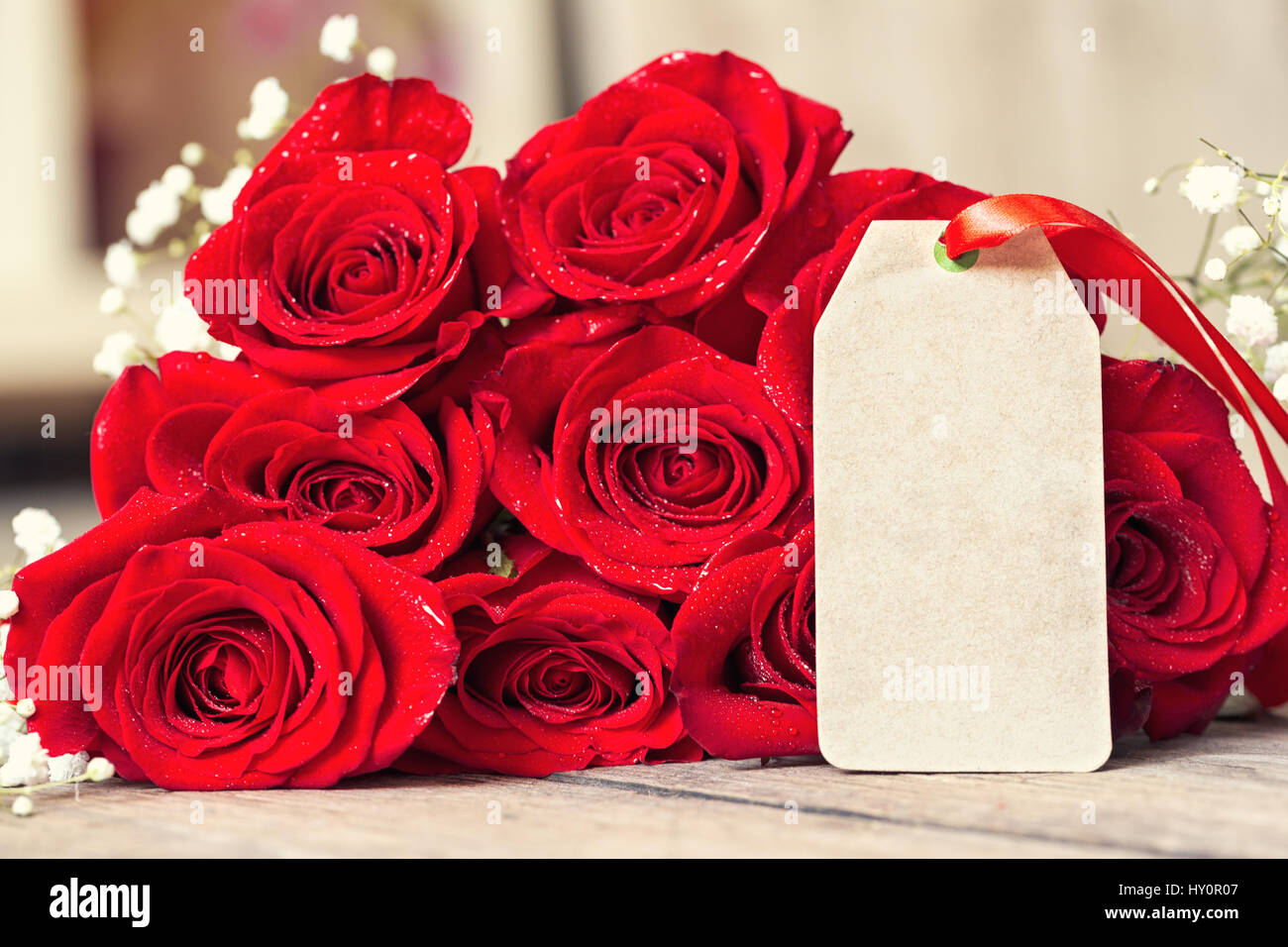 Red roses with a blank gift tag background Stock Photo - Alamy