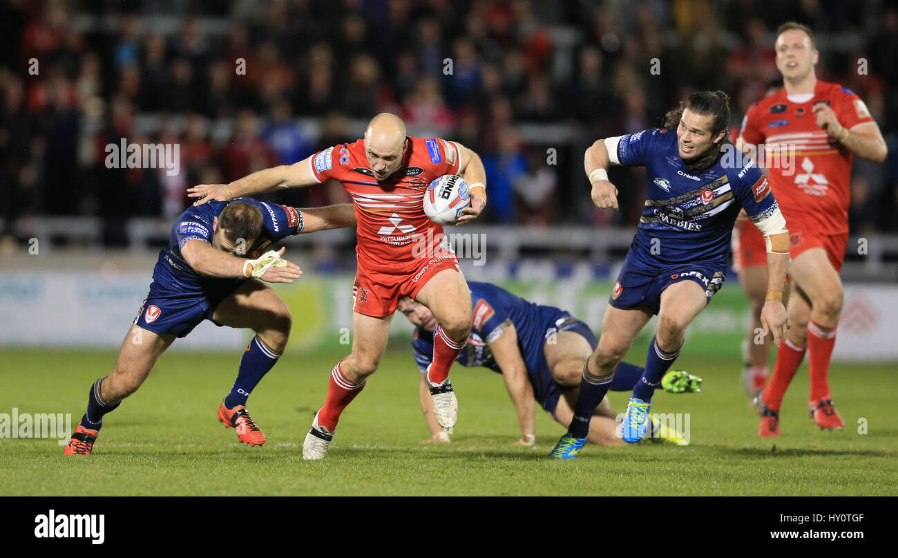 Salford Red Devils' Michael Dobson is tackled by St Helens' James Roby ...