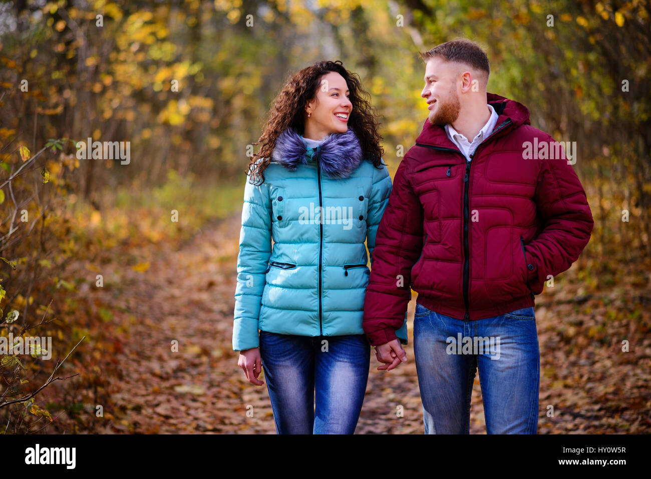 Lovers walking hand in hand in autumn park Stock Photo - Alamy