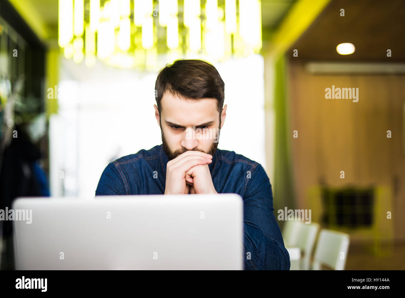 Portrait of thinking man using laptop computer at cafe shop copyspace ...