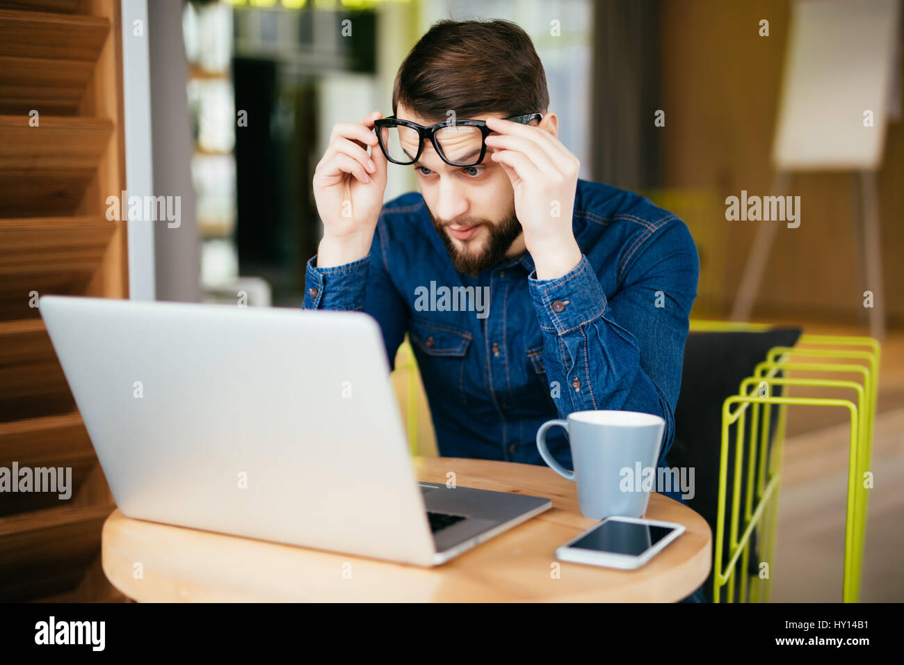 Business man with glasses having eyesight problems confused with laptop ...
