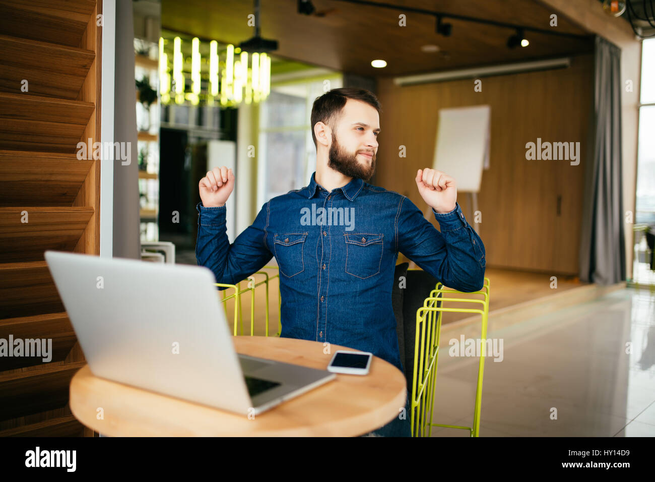 Happy excited young man sitting on workplace and celebrating success ...