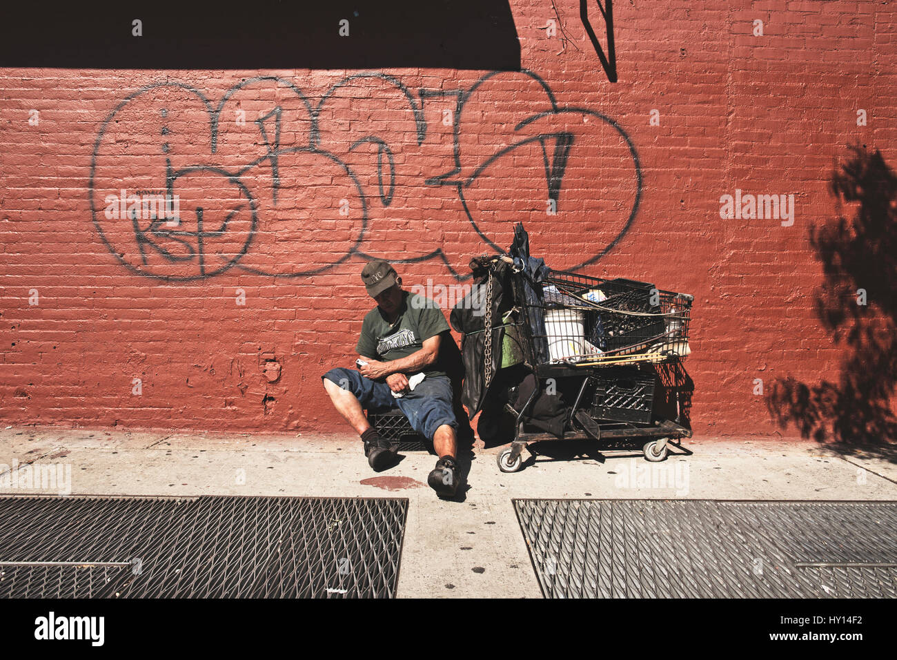 A homeless man is sitting and sleeping on street in New York, United ...