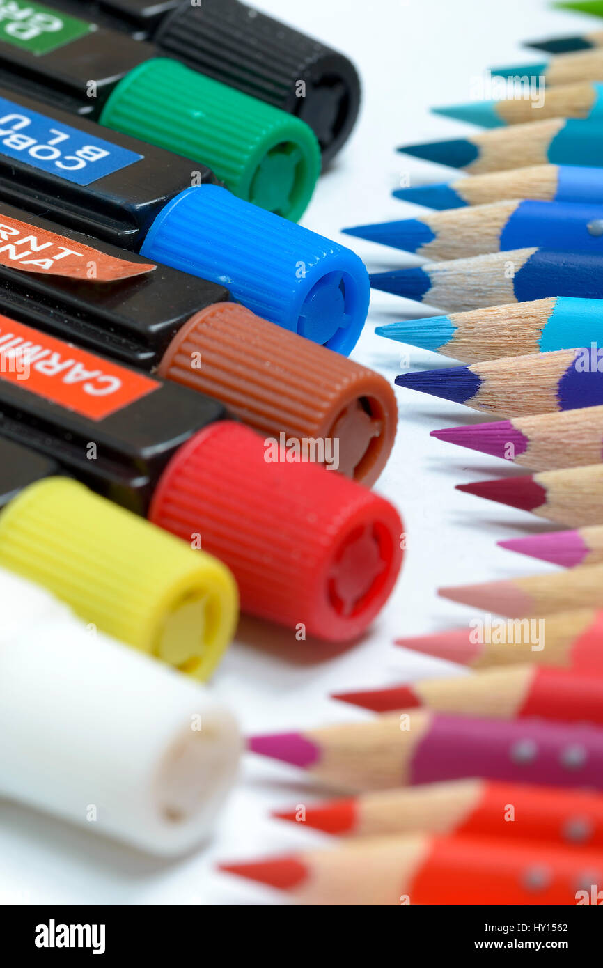 Bundle of colored pencils and tubes of paint on the colorful background ...