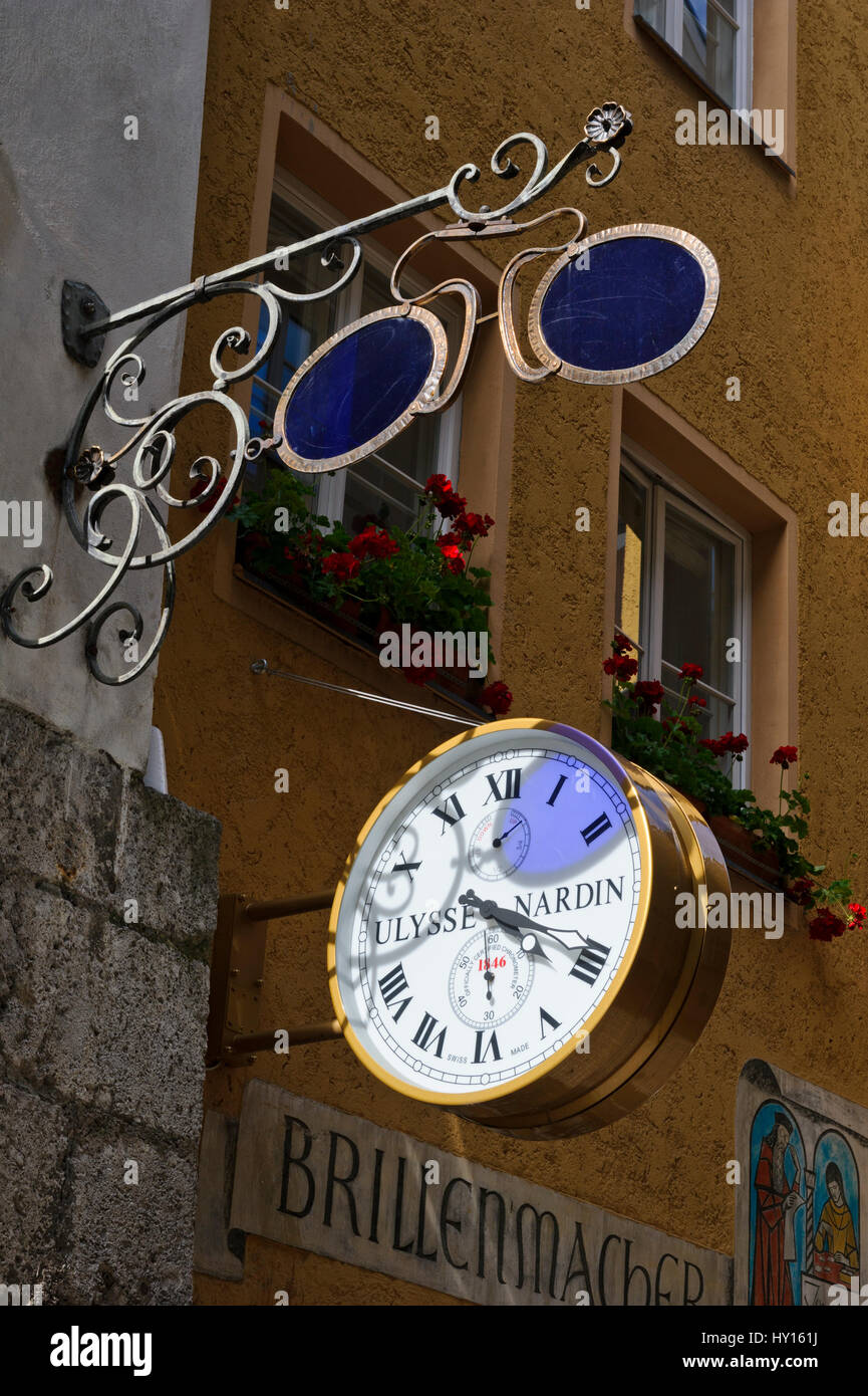 A clock and glasses sign hanging on the wall of a shop, Innsbruck ...