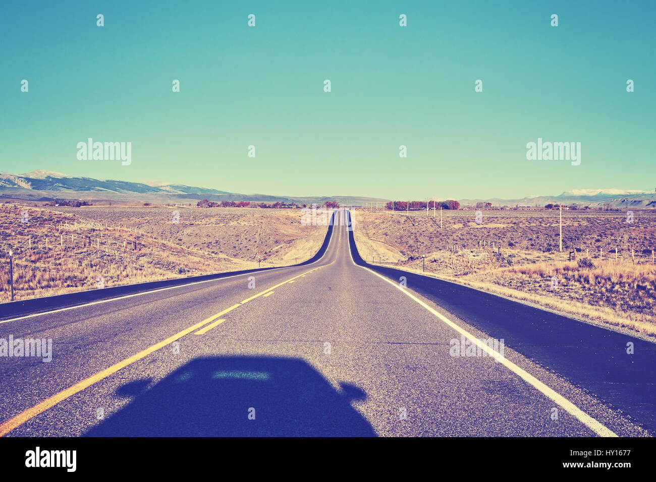 Vintage stylized shadow of a car on an empty road, travel concept, USA ...