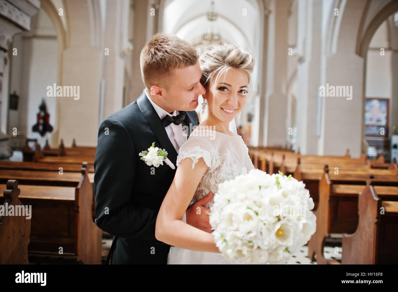 Photosession of stylish wedding couple on catholic church Stock Photo ...