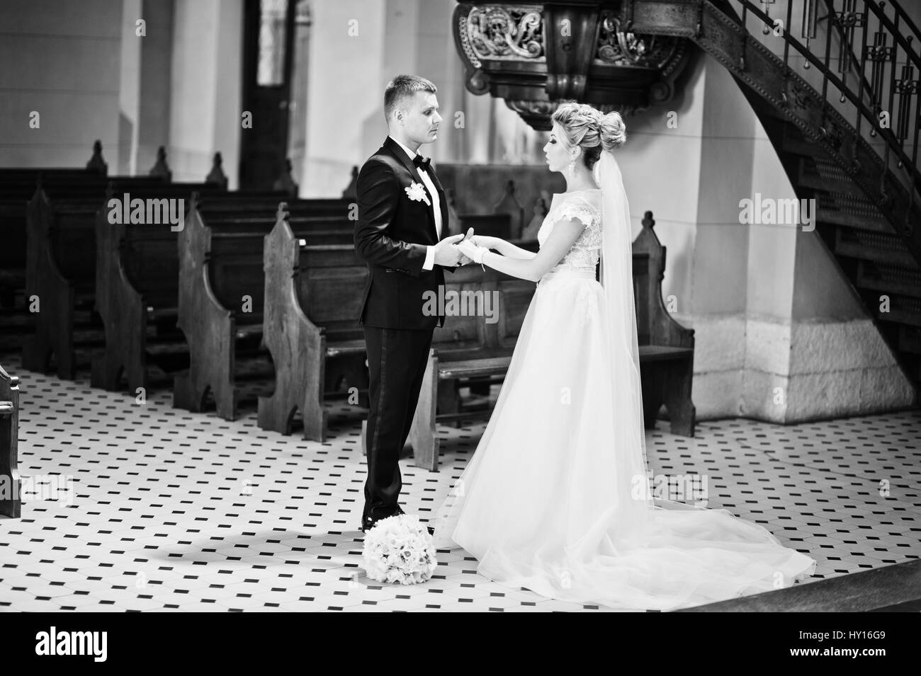 Photosession of stylish wedding couple on catholic church Stock Photo ...