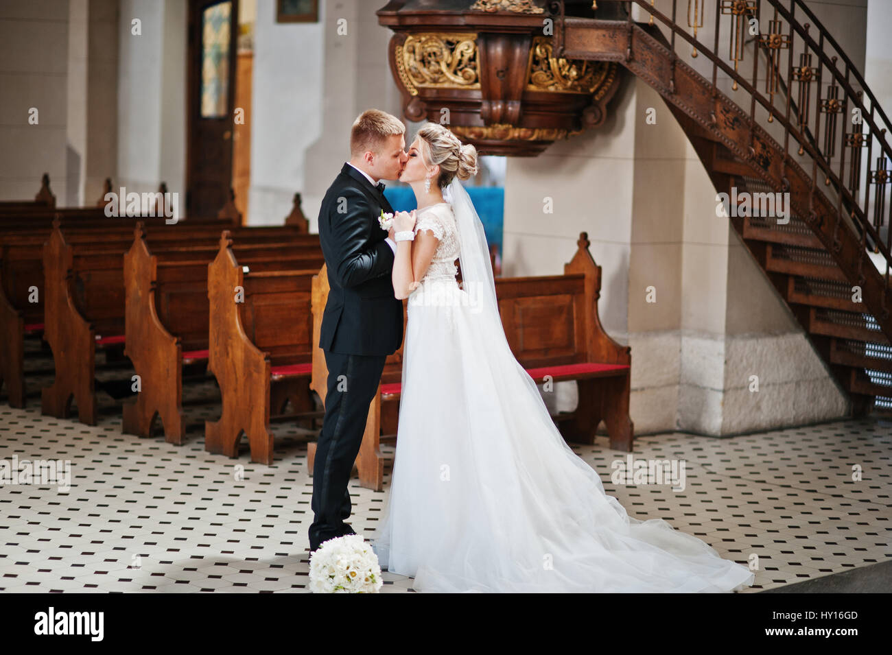 Photosession of stylish wedding couple on catholic church Stock Photo ...