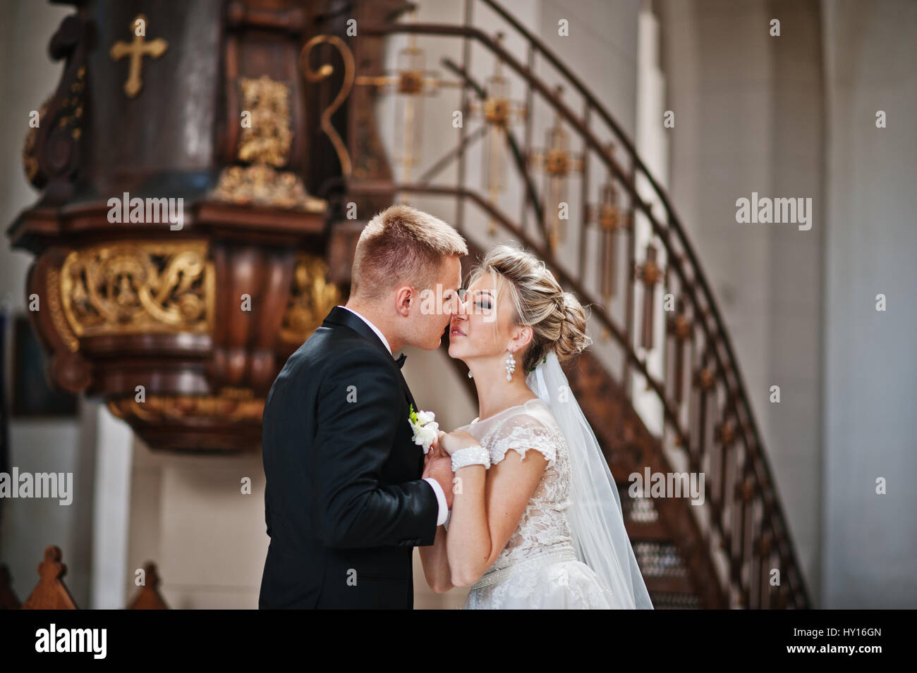 Photosession of stylish wedding couple on catholic church Stock Photo ...