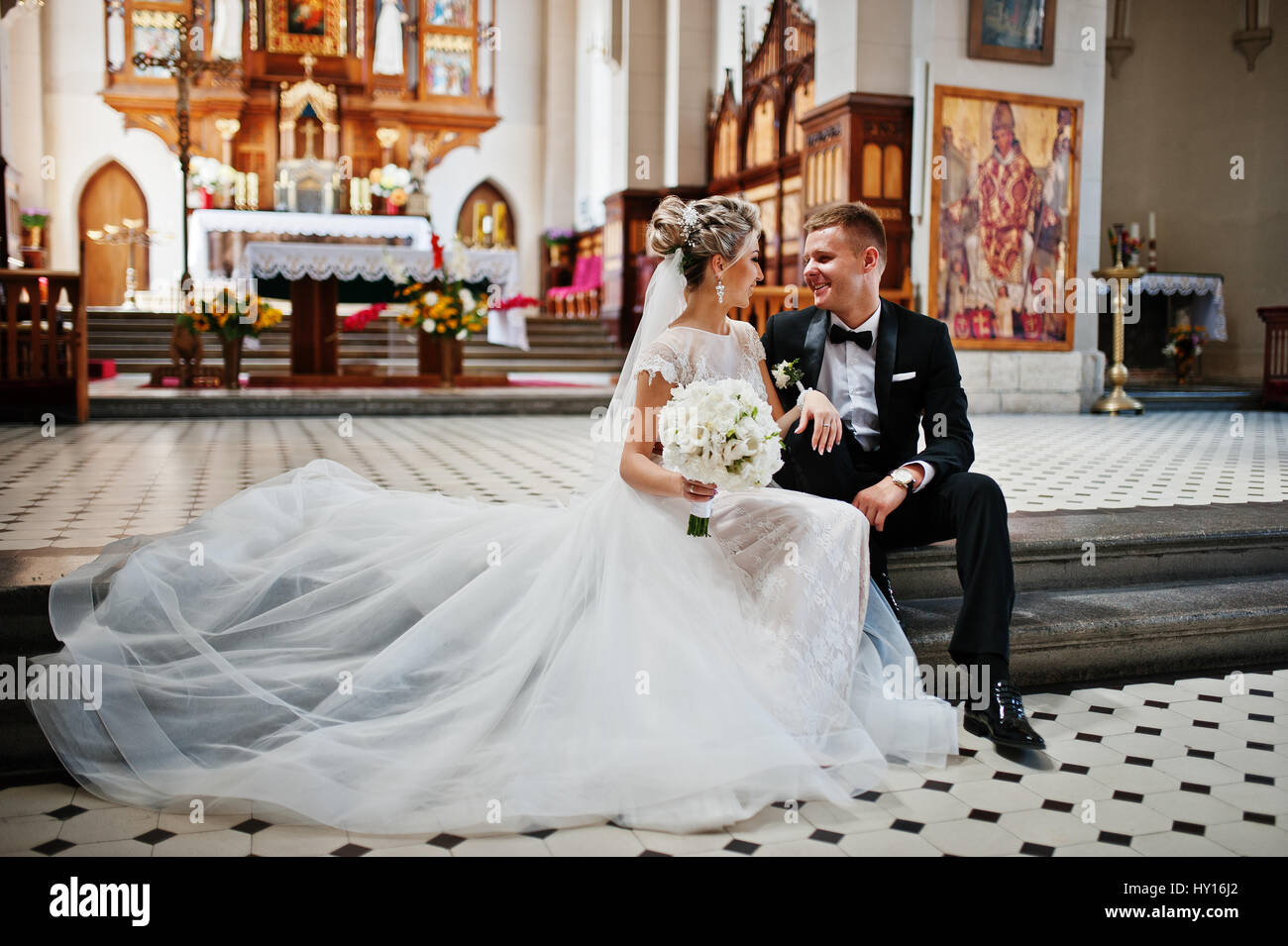 Photosession of stylish wedding couple on catholic church Stock Photo ...