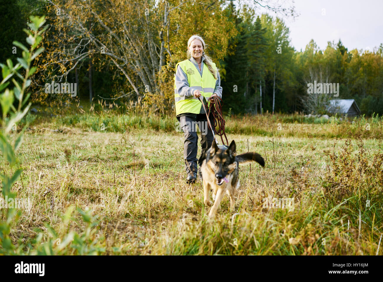 Sweden, Uppland, Rison, Portrait of volunteer with dog helping ...