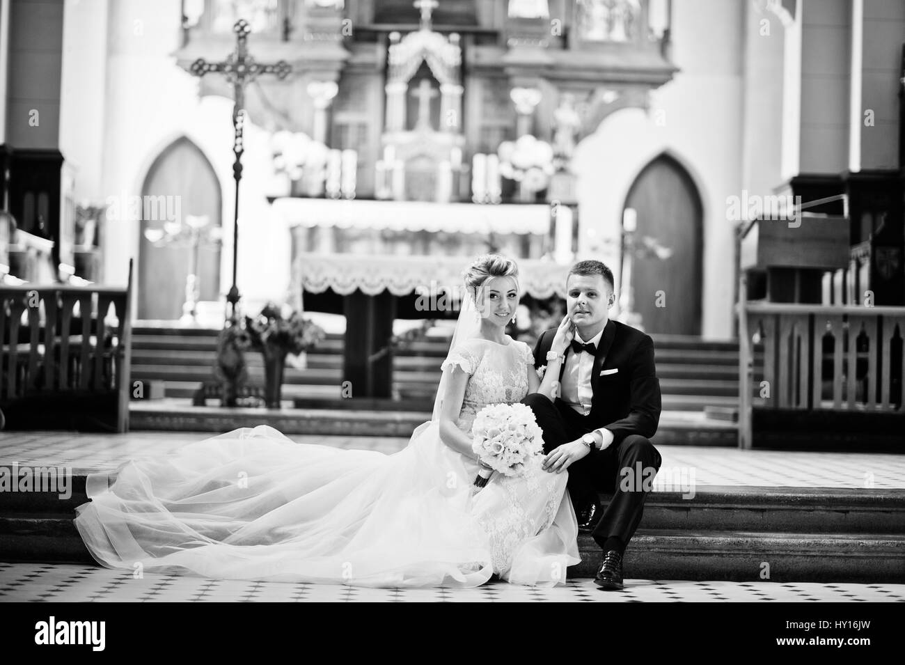 Photosession of stylish wedding couple on catholic church Stock Photo ...