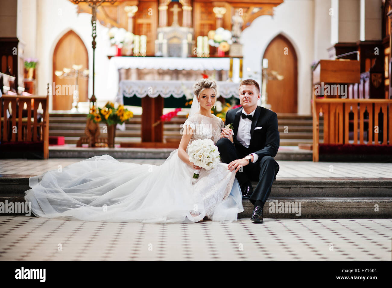 Photosession of stylish wedding couple on catholic church Stock Photo ...