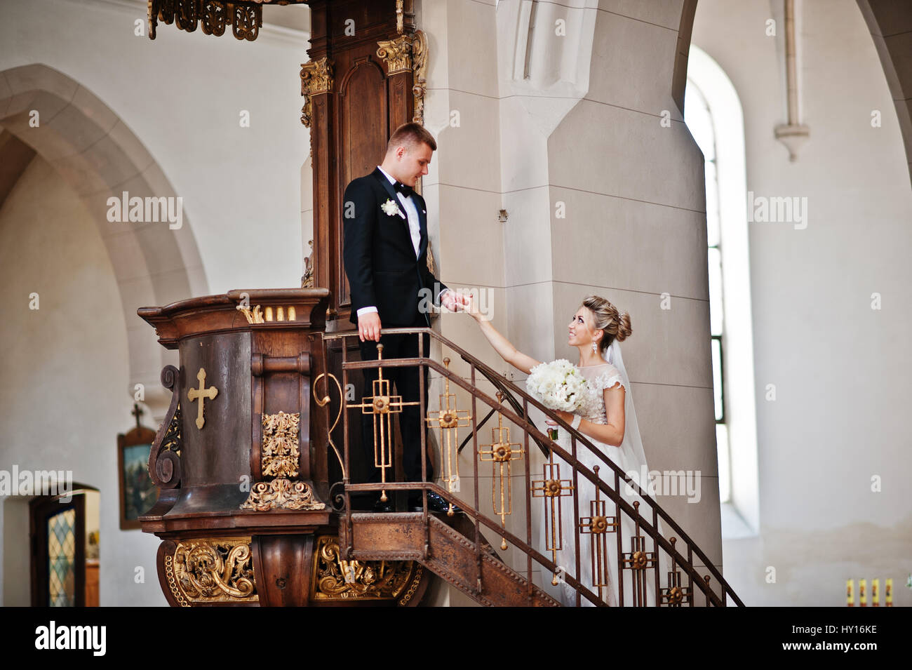 Photosession of stylish wedding couple on catholic church Stock Photo ...