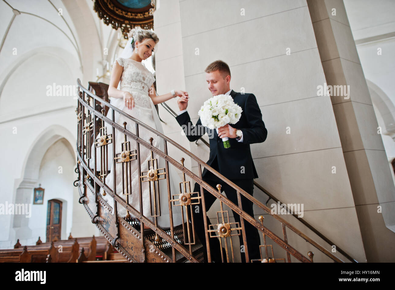 Photosession of stylish wedding couple on catholic church Stock Photo ...
