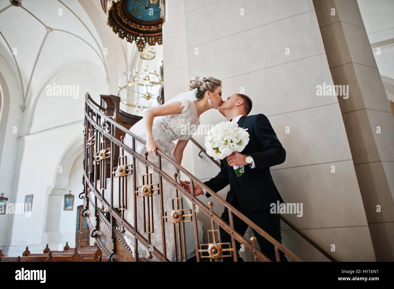 Photosession of stylish wedding couple on catholic church Stock Photo ...