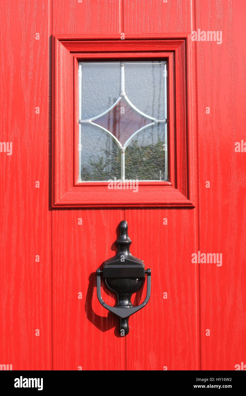 Red door with window and black knocker Stock Photo - Alamy
