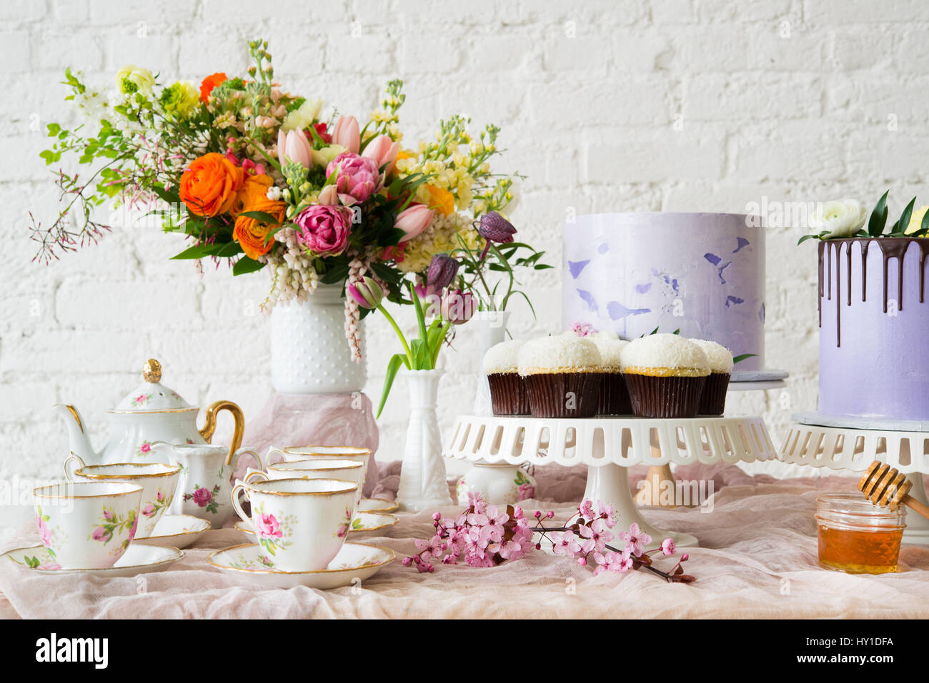 Horizontal image of a tea set with cupcakes, cake, and a bouquet of ...