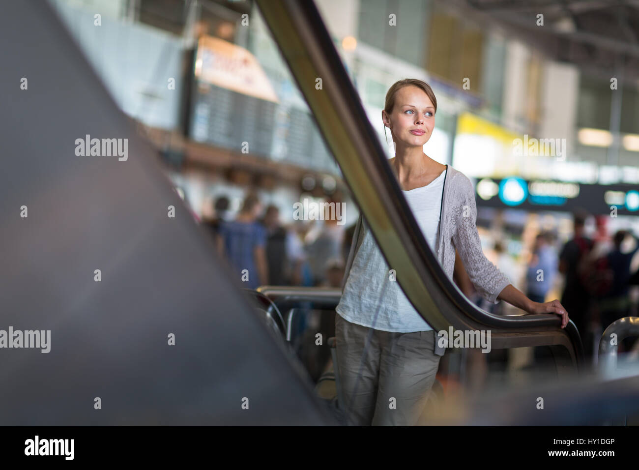 Young female passenger at the airport, about to check-in Stock Photo ...