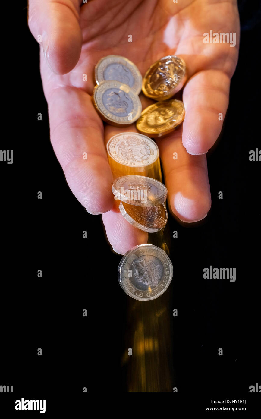 pound coins falling from man's hand Stock Photo - Alamy