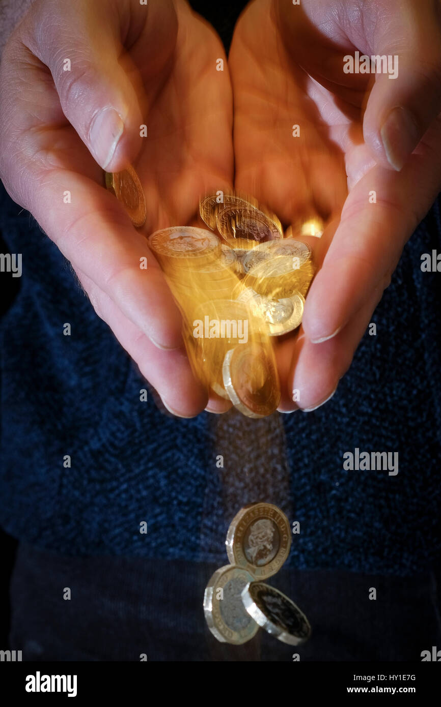 pound coins falling from man's hand Stock Photo - Alamy