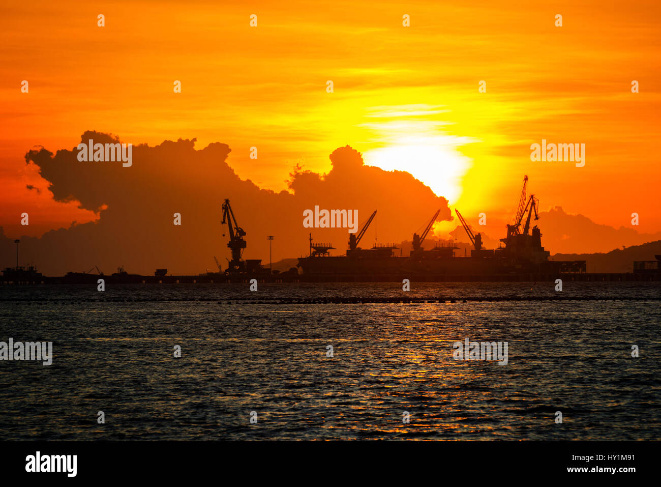 Beautiful sunset scene, commercial dock with ship and cranes in sunset ...