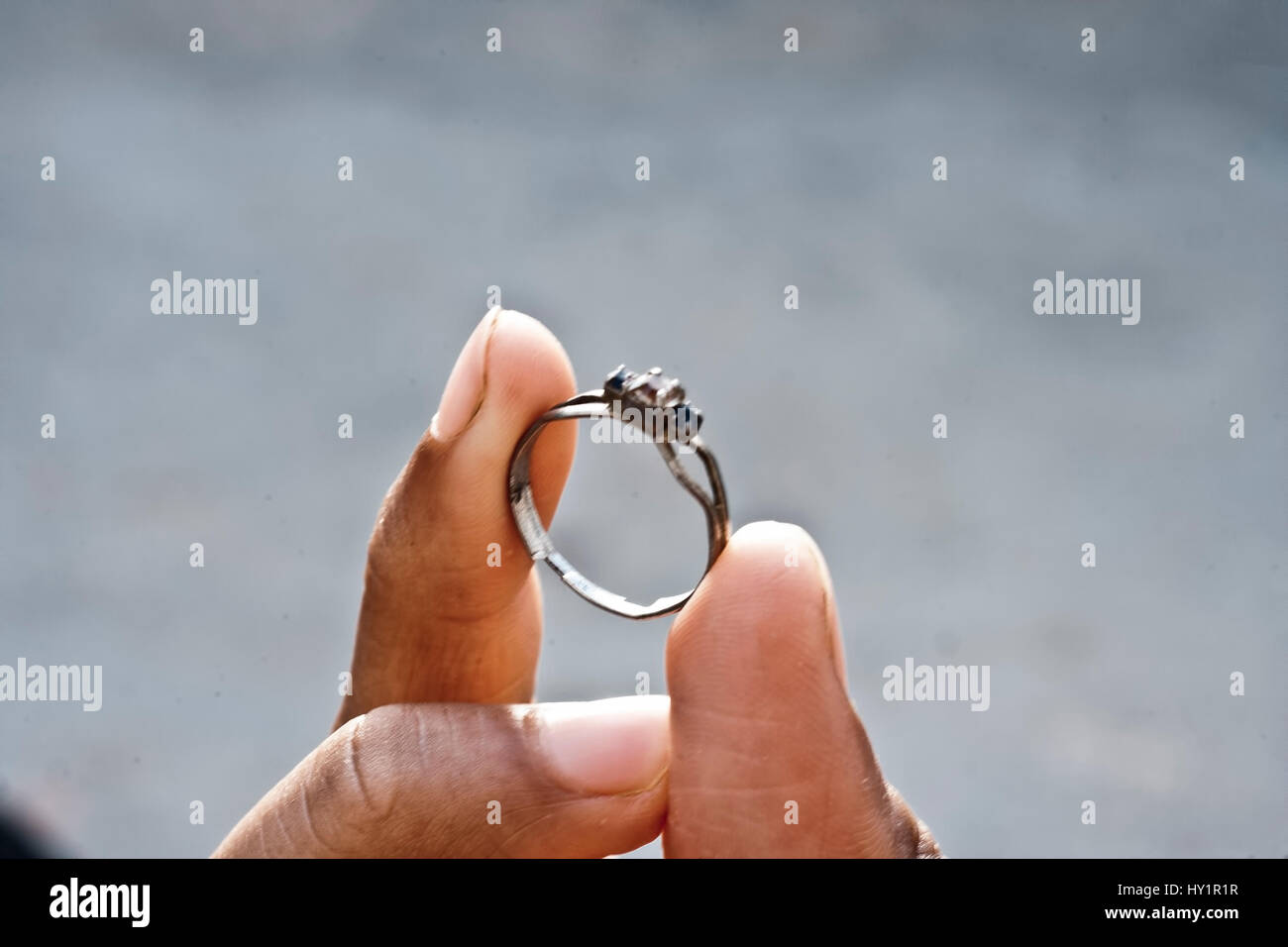 human hand holding wedding ring Stock Photo - Alamy
