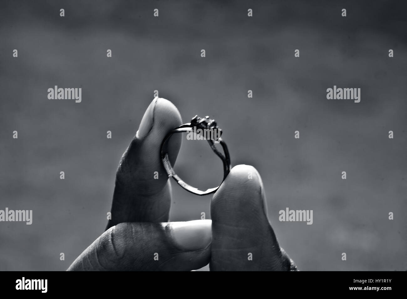 human hand holding wedding ring Stock Photo - Alamy