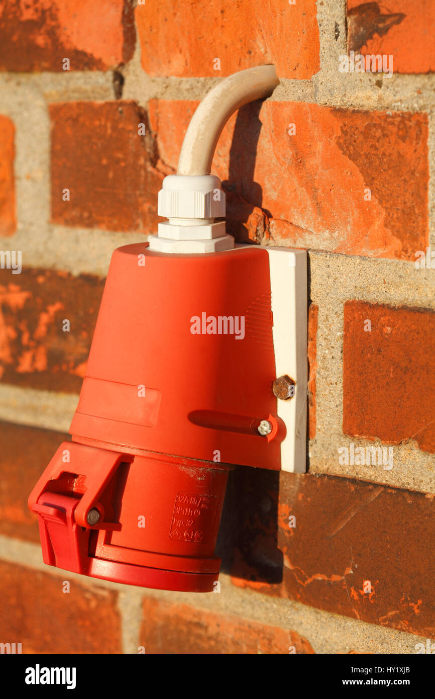 red plug on a red wall Stock Photo - Alamy