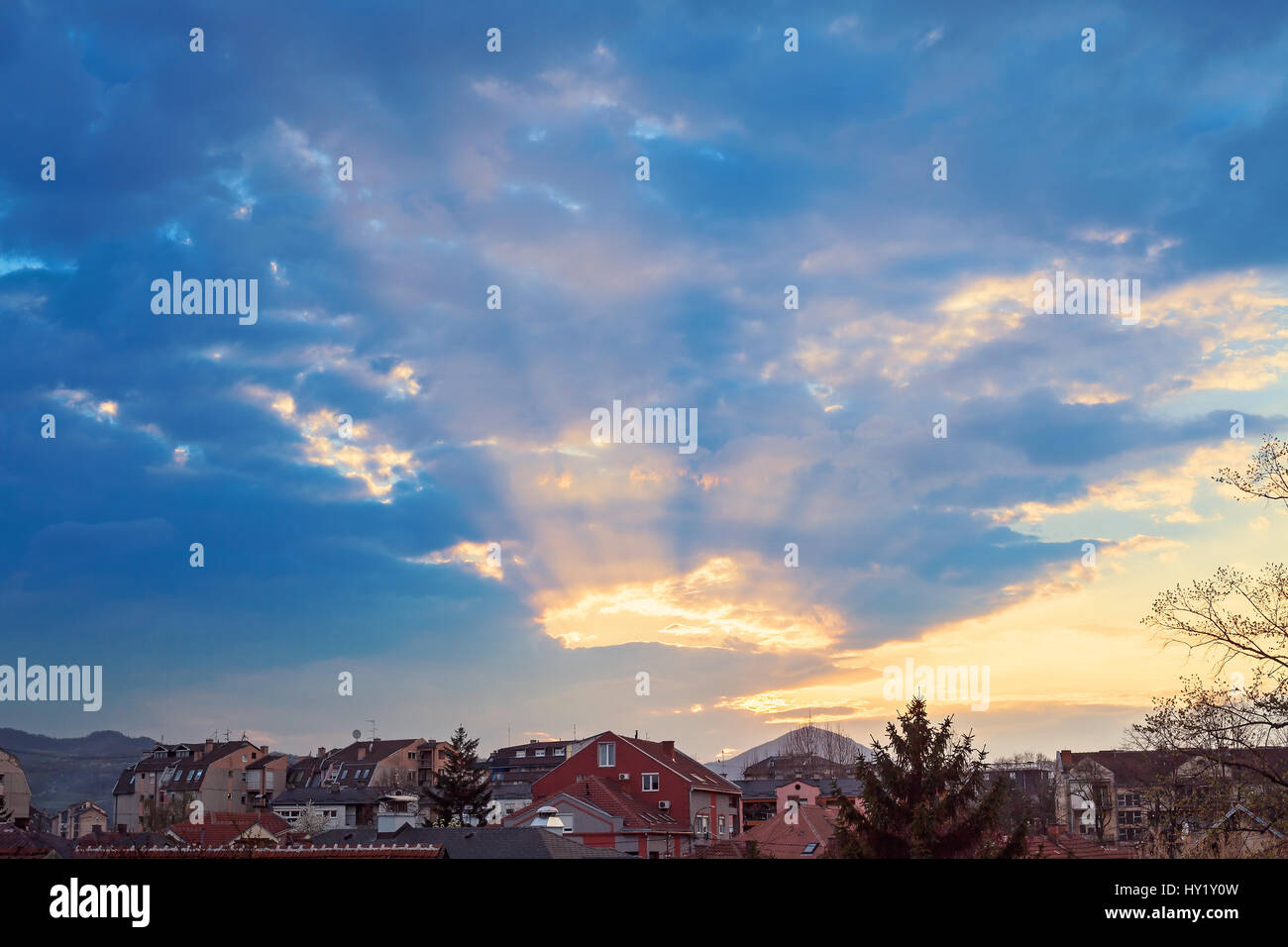 Landscape of a town, sunset moment with cloudy sky and some sun rays ...