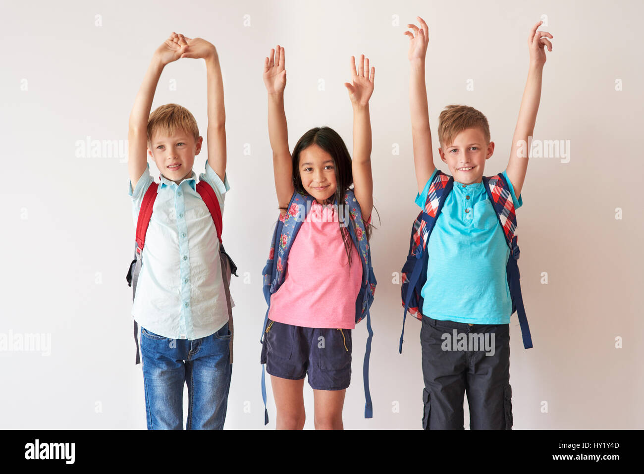 Three happy kids raising hands Stock Photo - Alamy