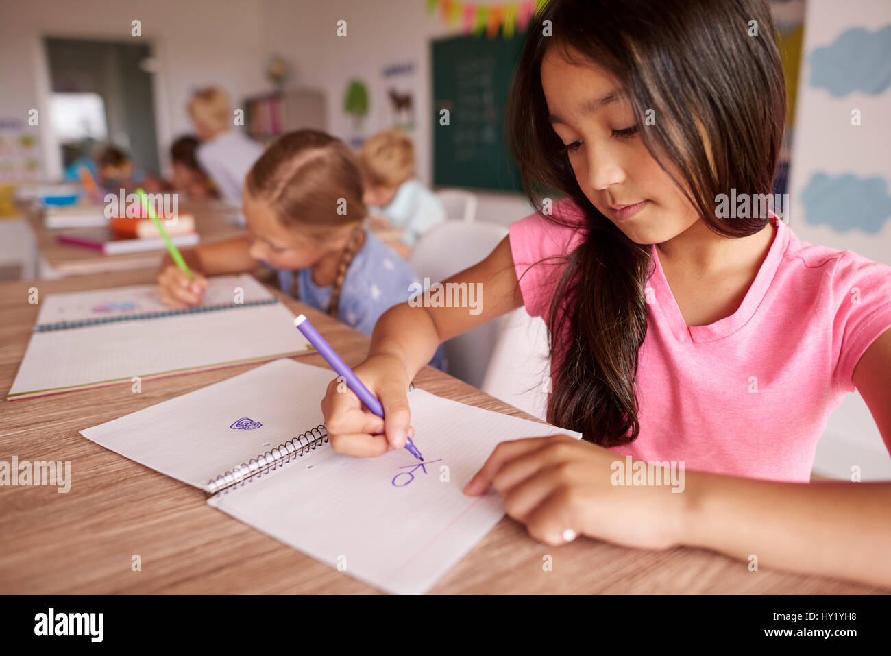 Dark hair girl drawing in the classroom Stock Photo - Alamy