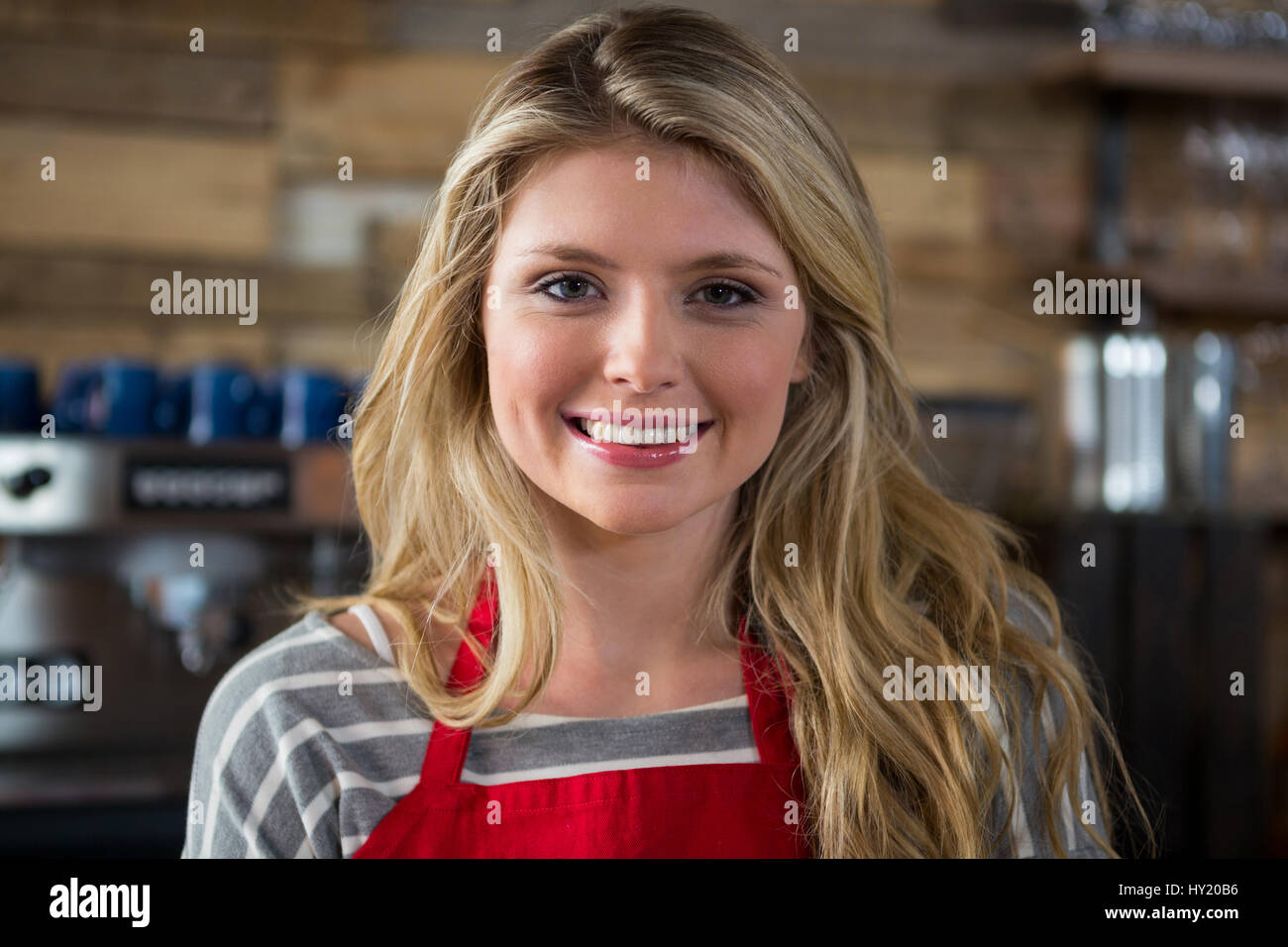 Close-up portrait of smiling young female barista in coffee shop Stock ...