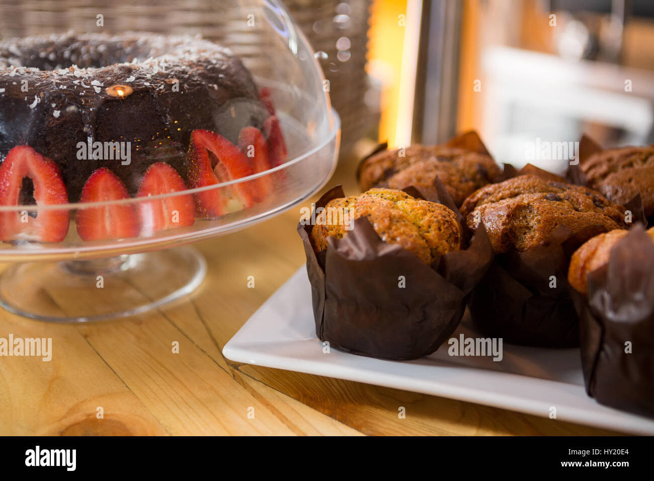 Close-up of muffins and cake on counter in coffee shop Stock Photo - Alamy
