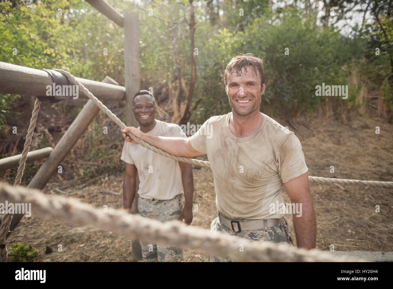 Portrait of military soldiers smiling during obstacle training at boot ...
