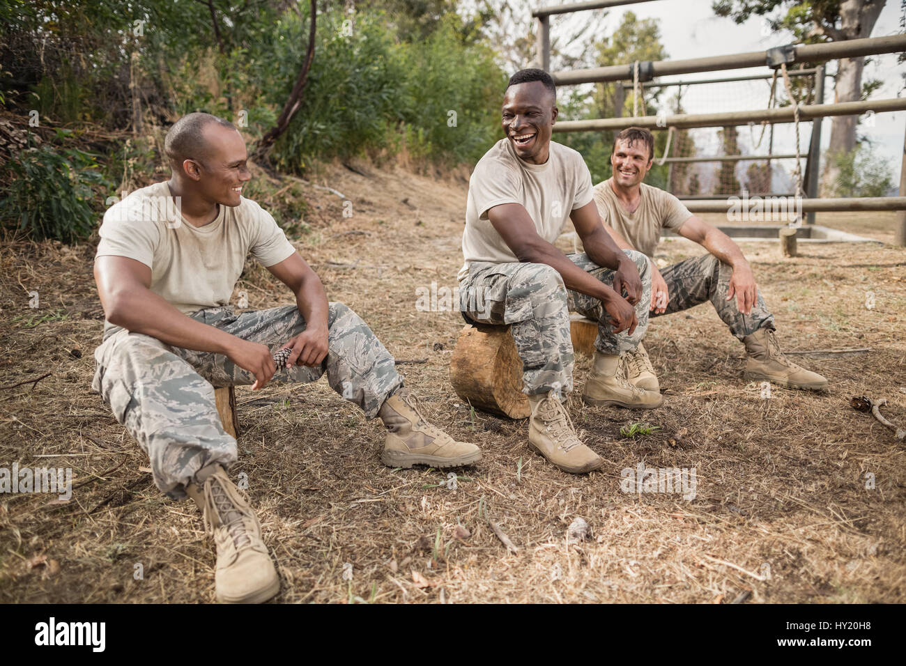 Military soldiers interacting during obstacle training at boot camp ...