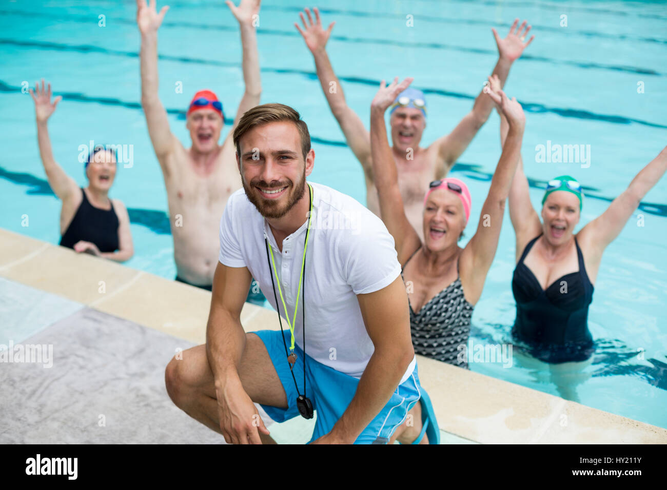 Portrait of male instructor with carefree senior swimmers in pool Stock ...