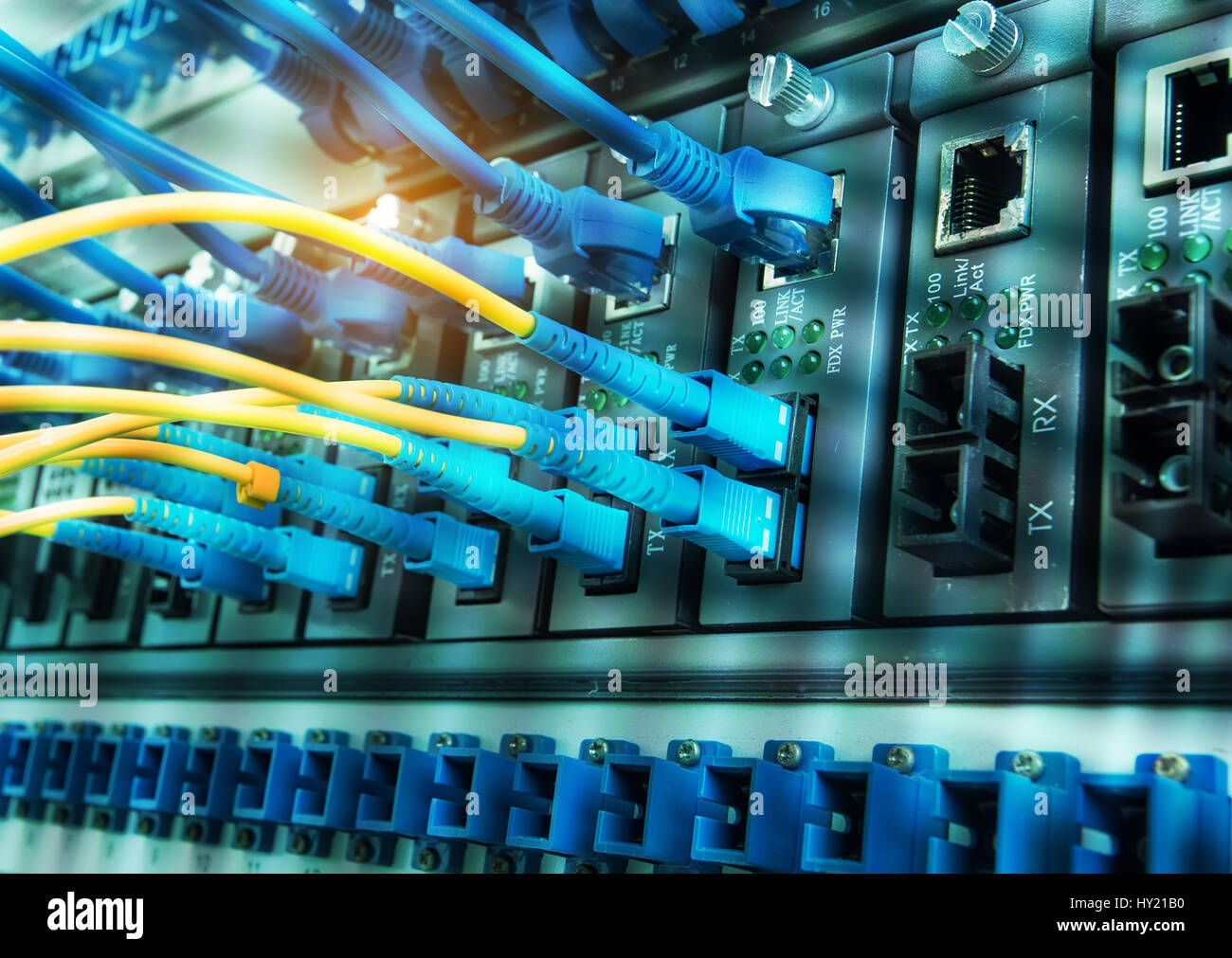 Fiber Optic cables connected to an optic ports and Network cables ...