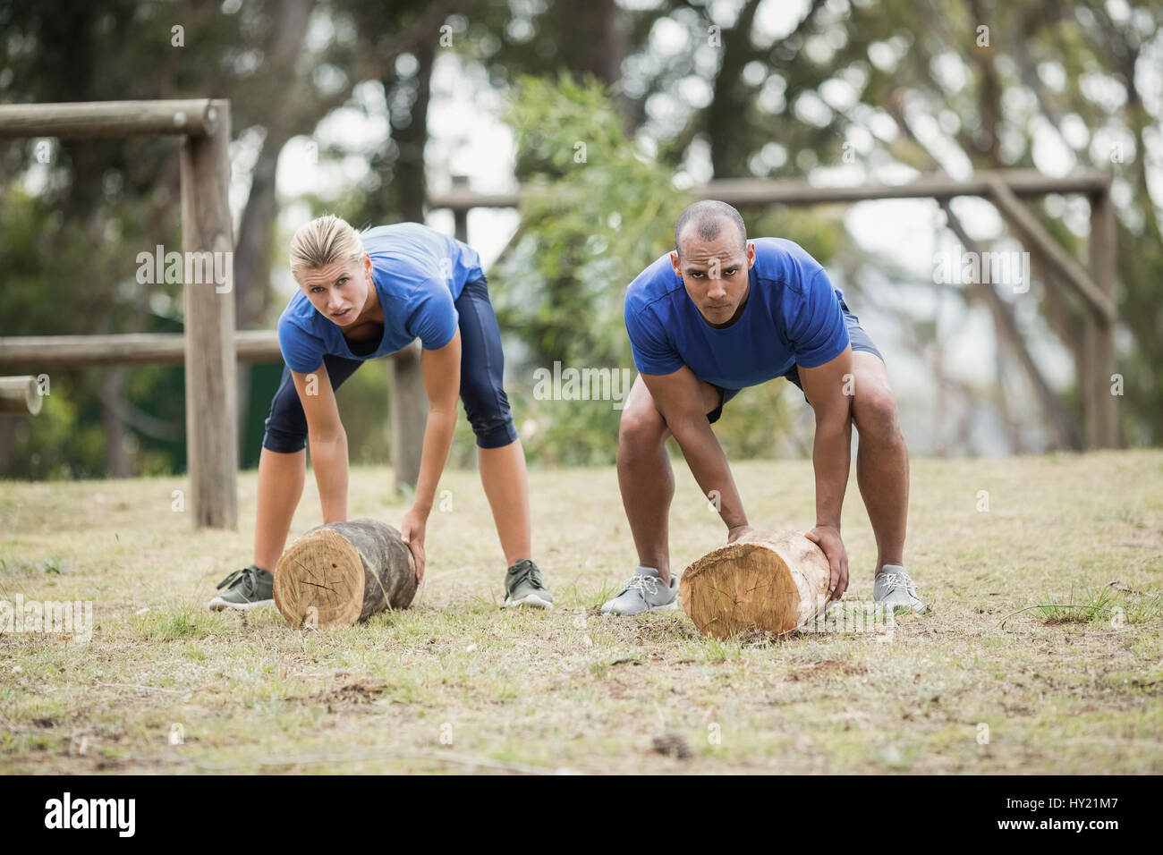 People carrying heavy wooden logs during obstacle course in boot camp ...